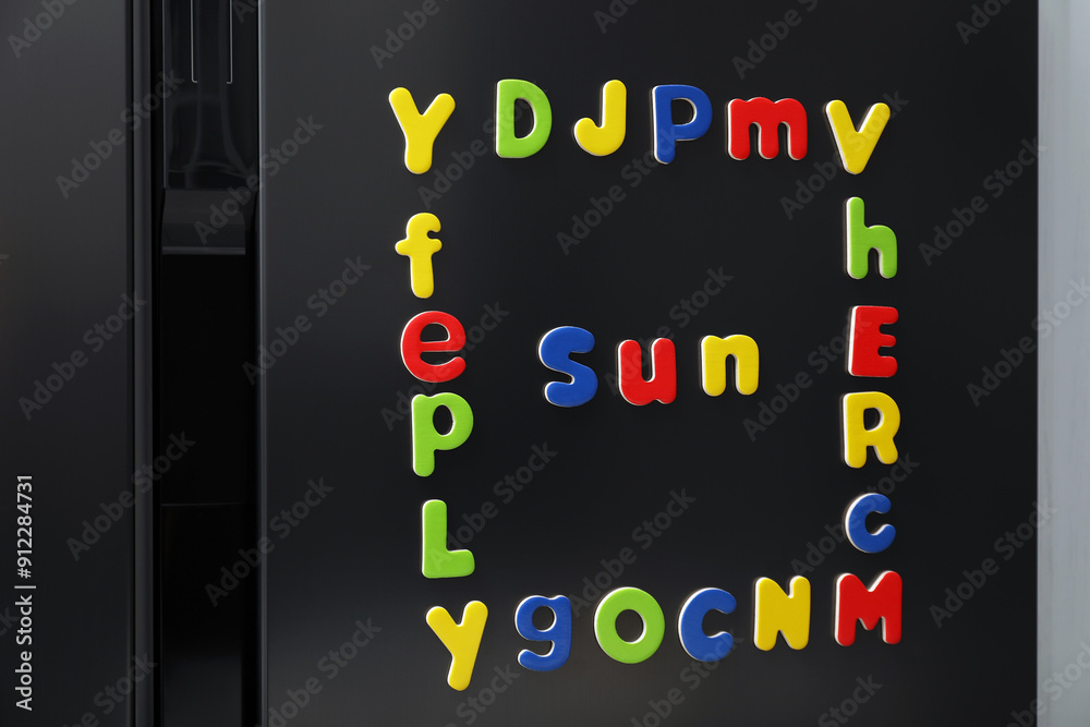 Word Sun and frame made of many bright magnetic letters on fridge ...