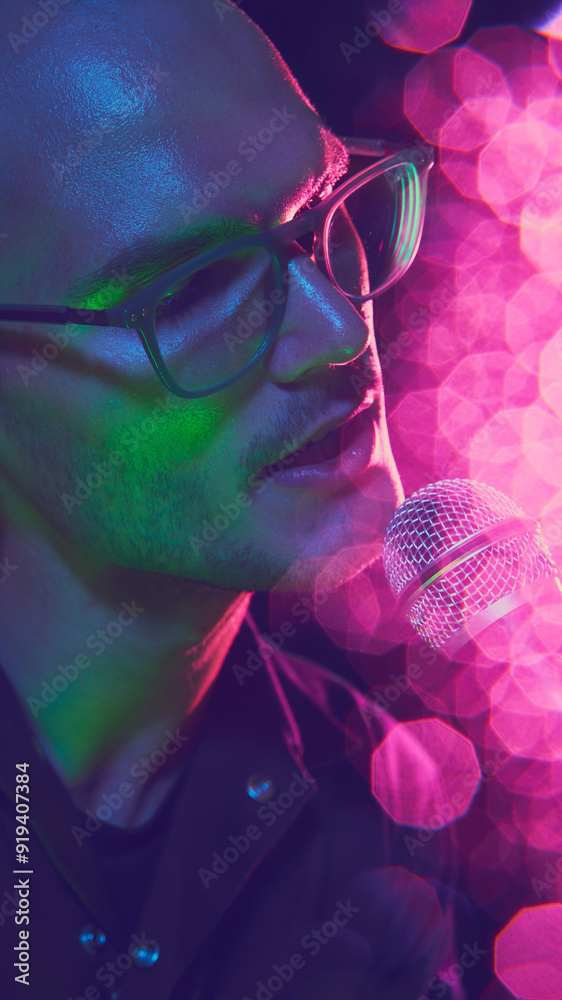 Neon hues reflect off singer's face as he belt out powerful note ...