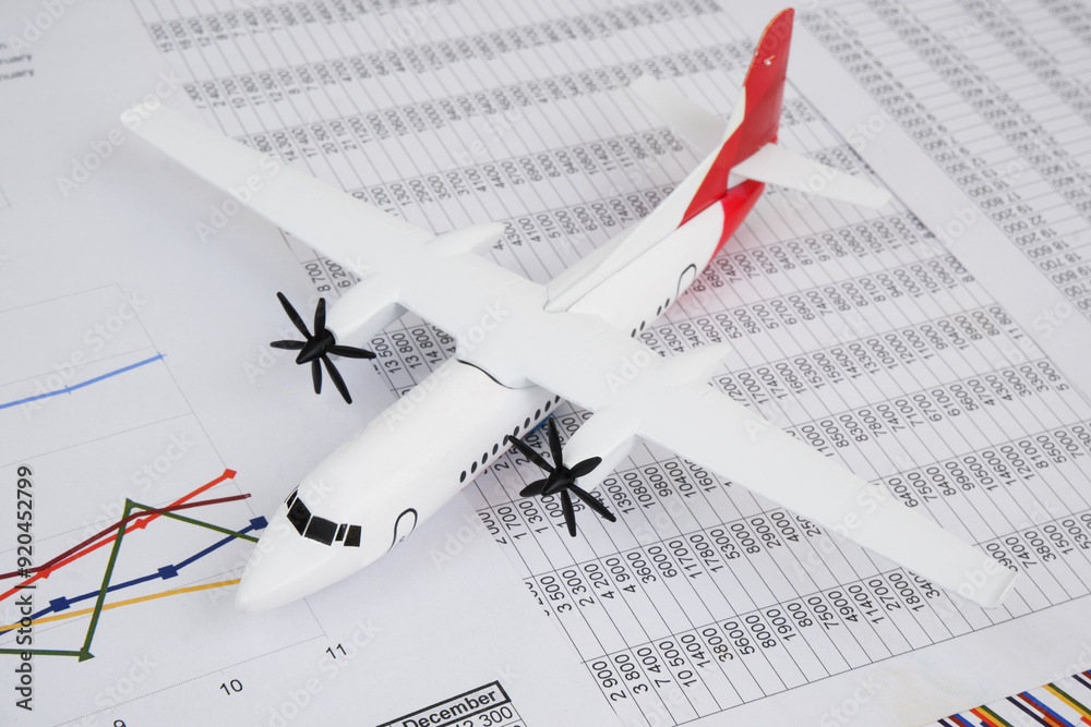 Airplane model on financial report pages close up. Managing airway's ...