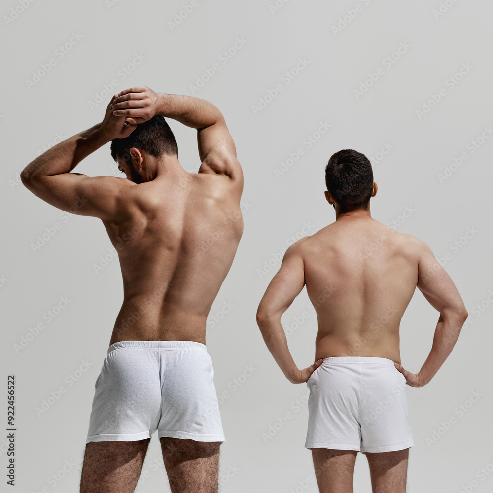 Rear view photo of two young men posing shirtless showing their healthy ...