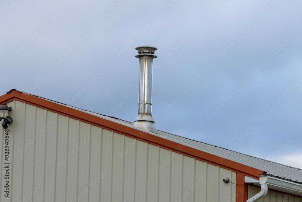 metal chimney on house roof, clean new shiny chimney pipe on blue sky ...