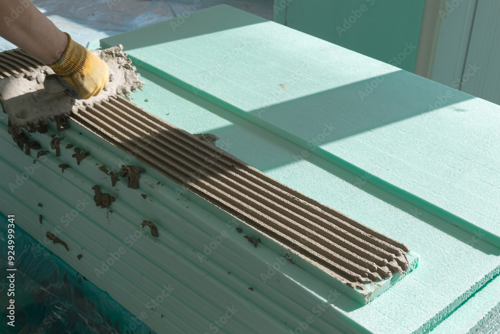 Construction worker applying adhesive mortar onto XPS (Extruded ...