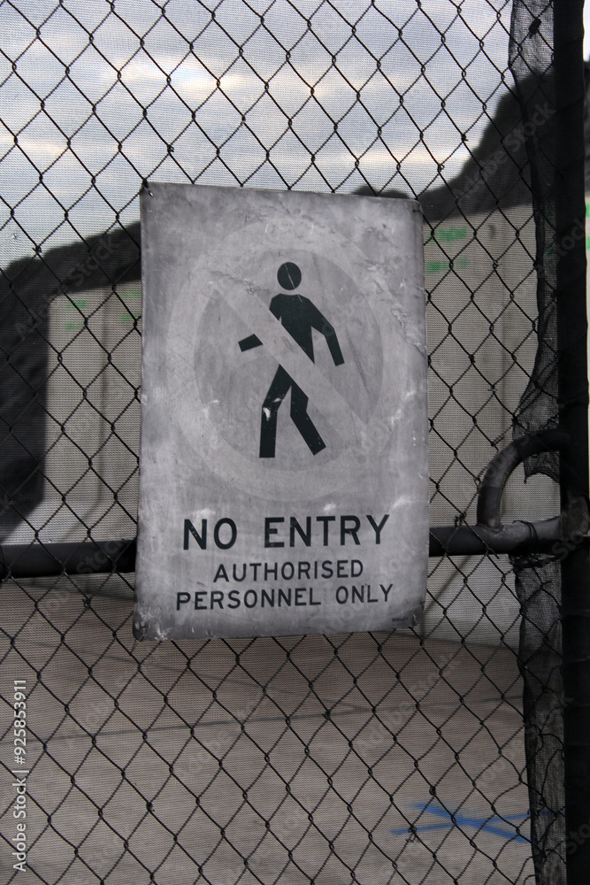 No Entry - Authorised Personnel Only sign attached to a chain-link ...