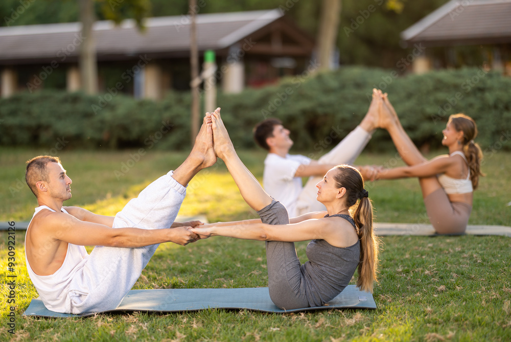 Smiling young woman and man performing boat pose Navasana in pair ...