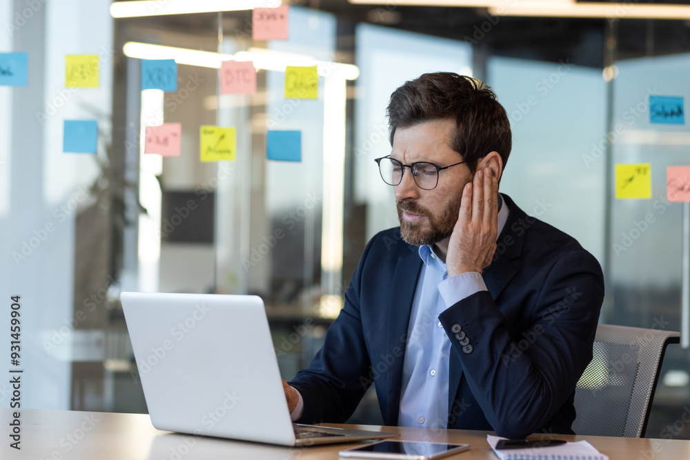 Business professional suffering from ear discomfort while engaged in ...