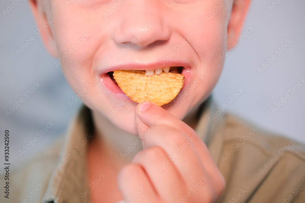 Child puts snack in his mouth with his hand and enjoys eating fast food ...