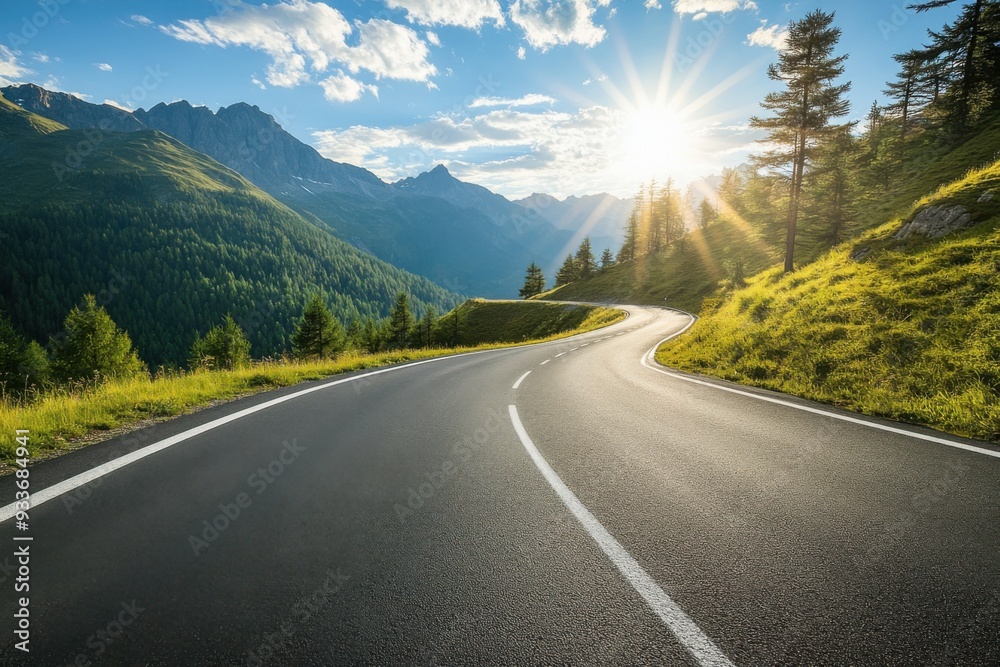 A winding road through a mountain landscape at sunrise with lush ...