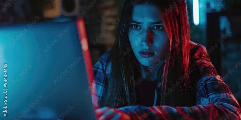 Female hacker engaged in cybersecurity tasks related to phishing and malware in a dim basement ...