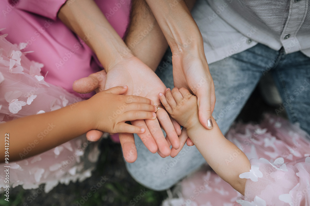 Family, parents and children, father and mother with girls daughters holding hands. Close-up ...
