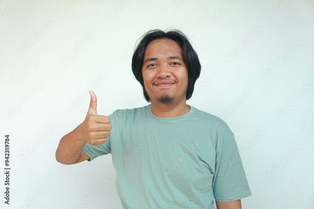 Excited and happy long haired Asian man gives thumbs up hand gesture of ...