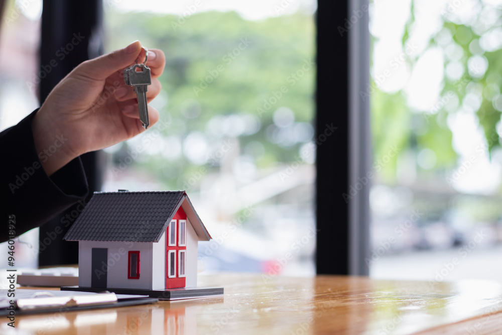 The real estate broker is handing over the house keys to the customer ...