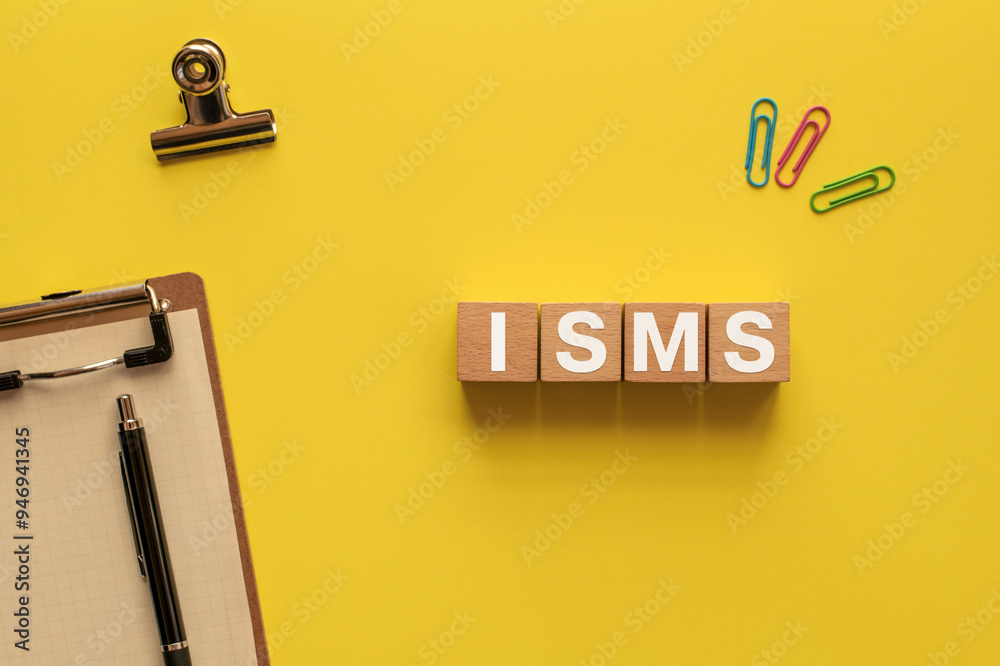 There is wood cube with the word ISMS. It is an abbreviation for Information Security Management ...