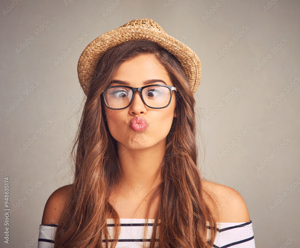 Kiss, girl and funny face with hat in studio for fun game, goofy ...