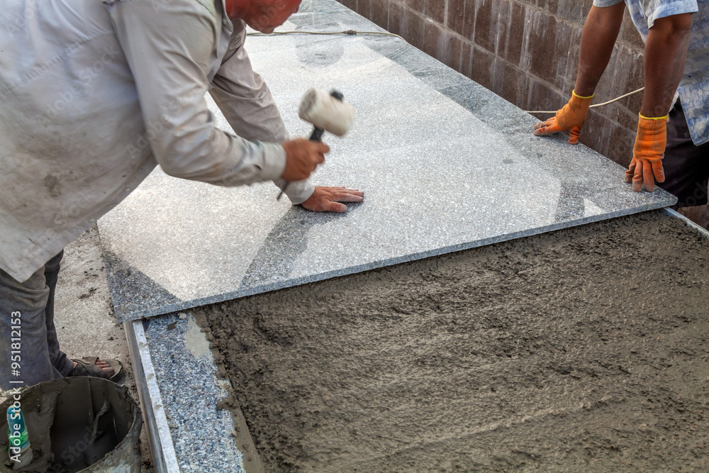 Laying granite slabs on cement mortar.Manual laying of granite slabs on ...
