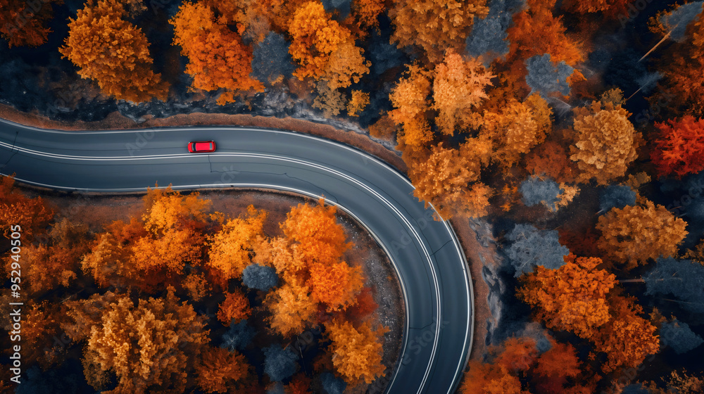 Aerial view of car traveling on a curvy road through autumn forest ...