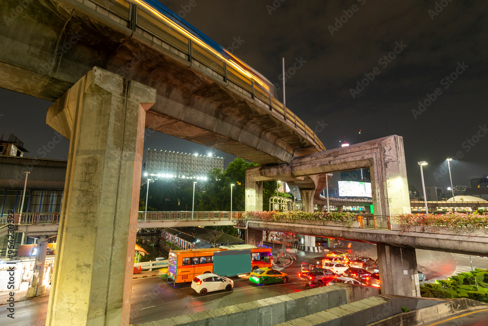 City night scene of elevated railway,trains running overhead, around ...
