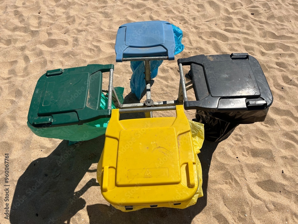 Waste separation on the beach, the different colors of the garbage bags ...