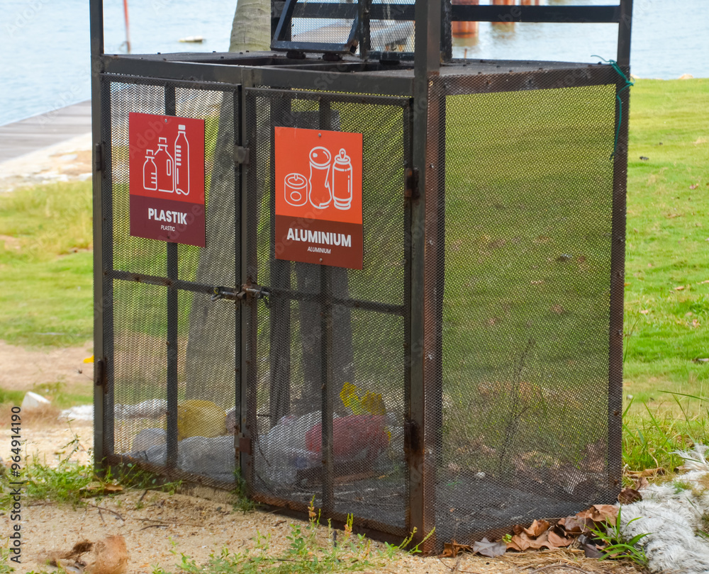 The metal bins, with their red signs and clear symbols, serve as ...