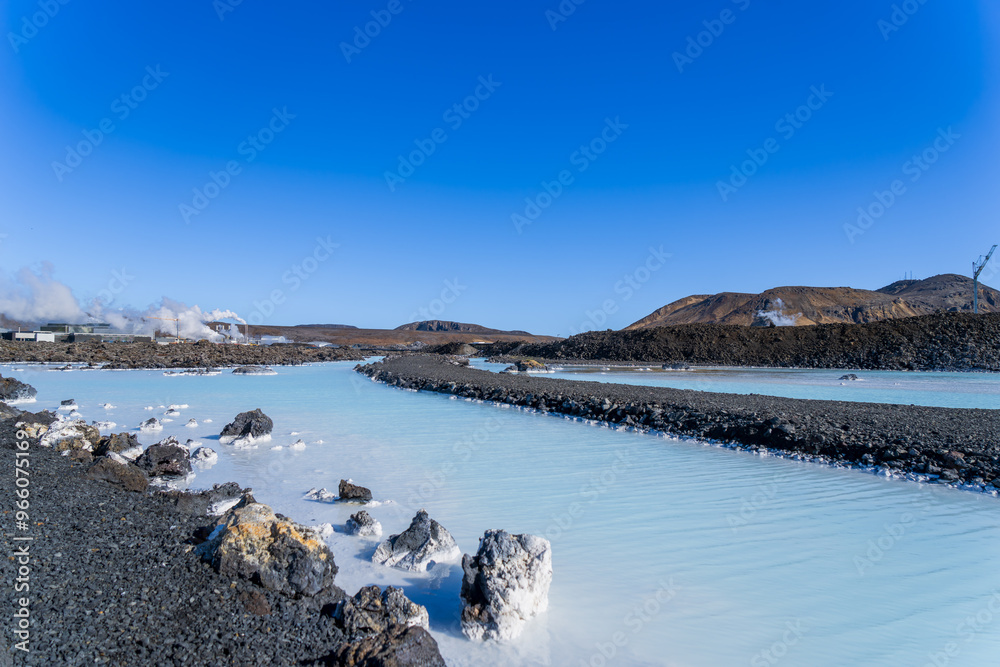 Milky blue waters of the Blue Lagoon in Iceland contrast with black ...