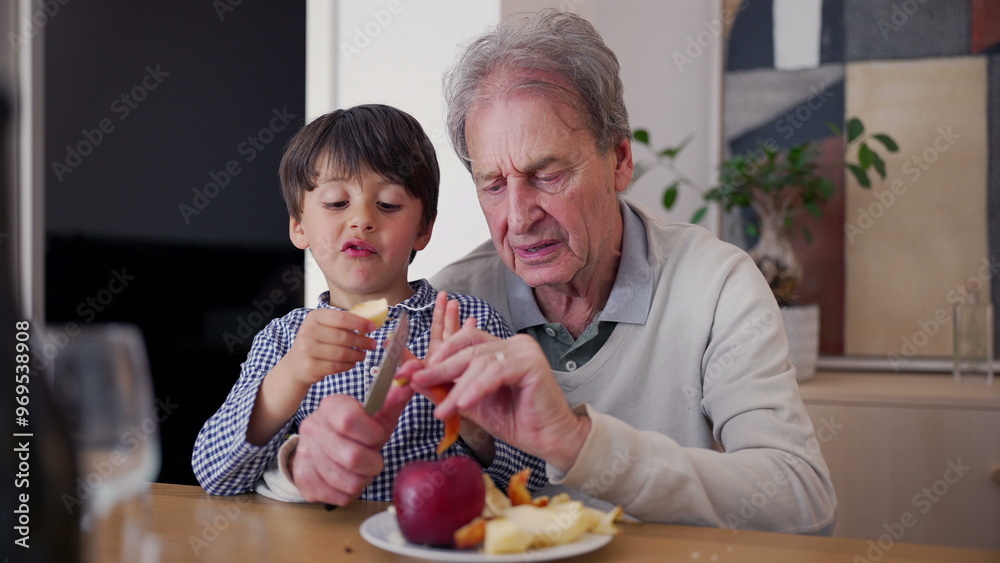Grandfather and grandson enjoying apple slices, family time ...