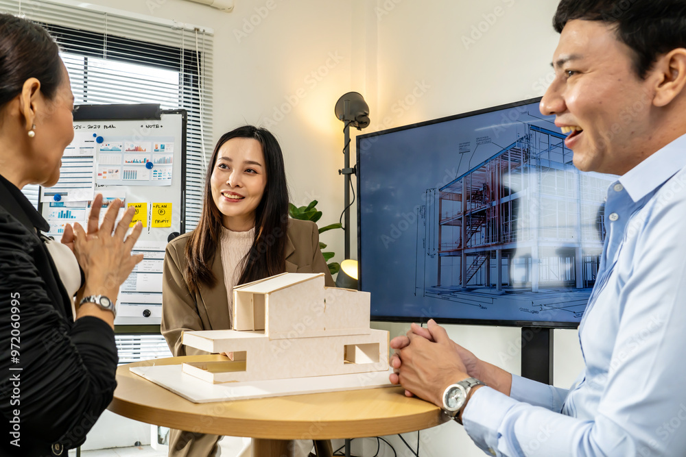 Real estate agent shows model house to two customers, male and female ...