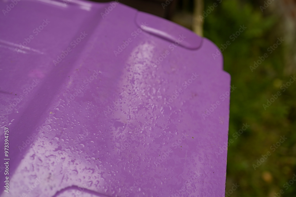 Purple lid on waste recycling wheelie bin close up in garden storage ...