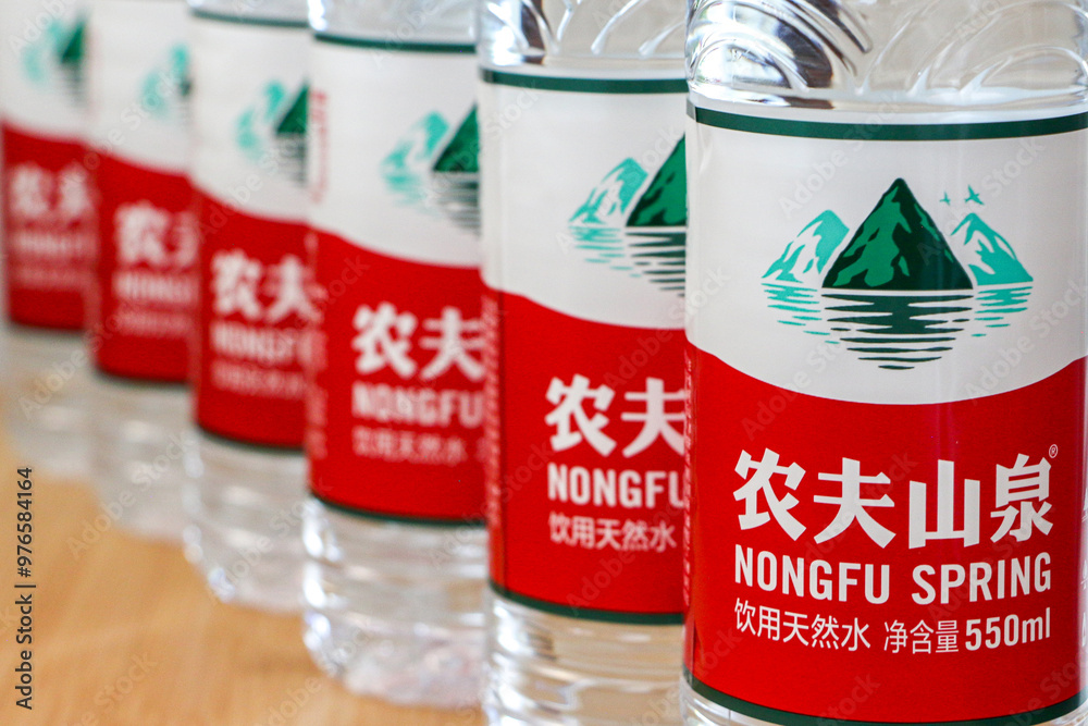Line of Nongfu Spring bottle natural water with logo on wooden surface ...