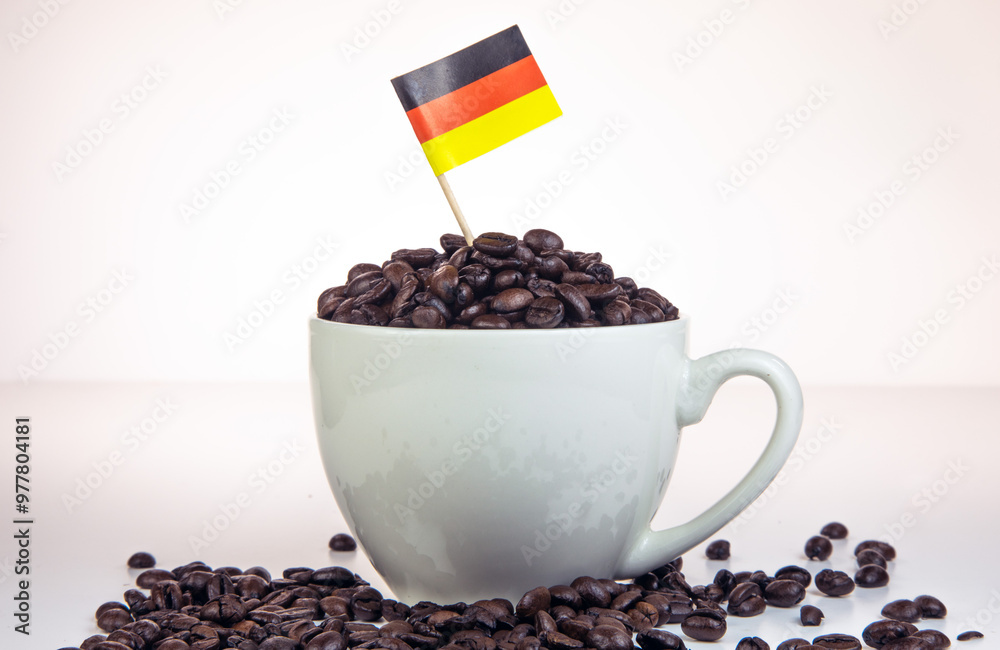 German flag sticking out of a white cup full of coffee beans on a white ...