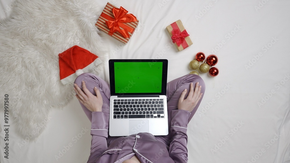 Top view of female sits on the bed using gadget with chroma key green ...