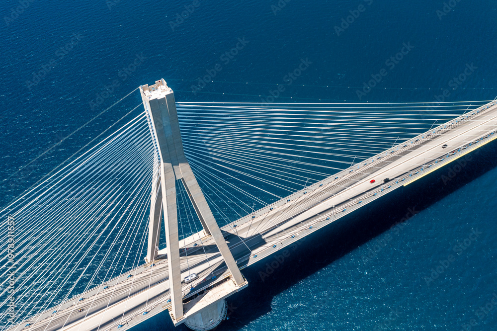 Aerial view of a beautiful suspension bridge crossing over clear blue ...