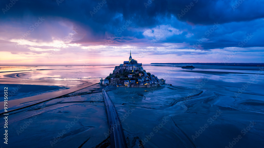 Aerial view of mont saint michel at blue hour with dramatic clouds and ...