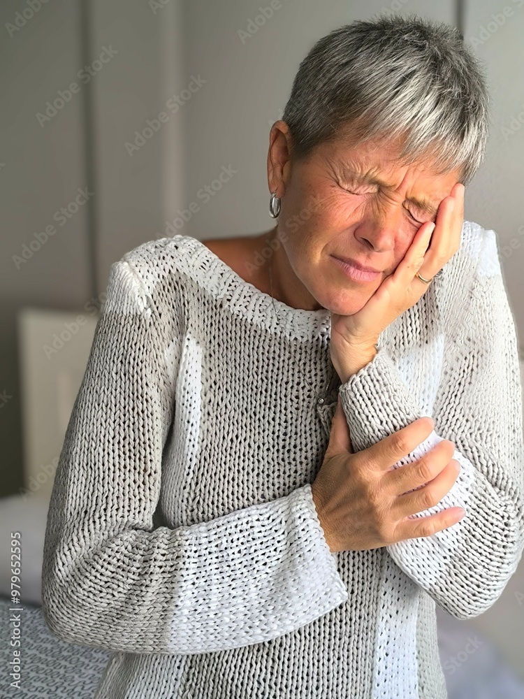 Stock-Foto „Young woman suffering from jaw pain holding chin with hands ...