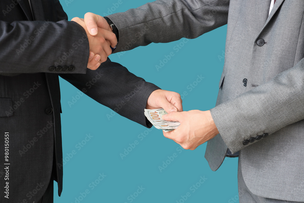 Young business men with bribe shaking hands on blue background, closeup ...
