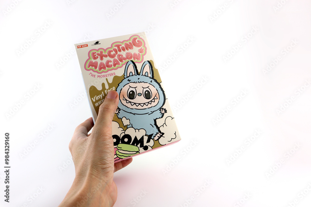 left hand holding an art toys Labubu key chain box package ...