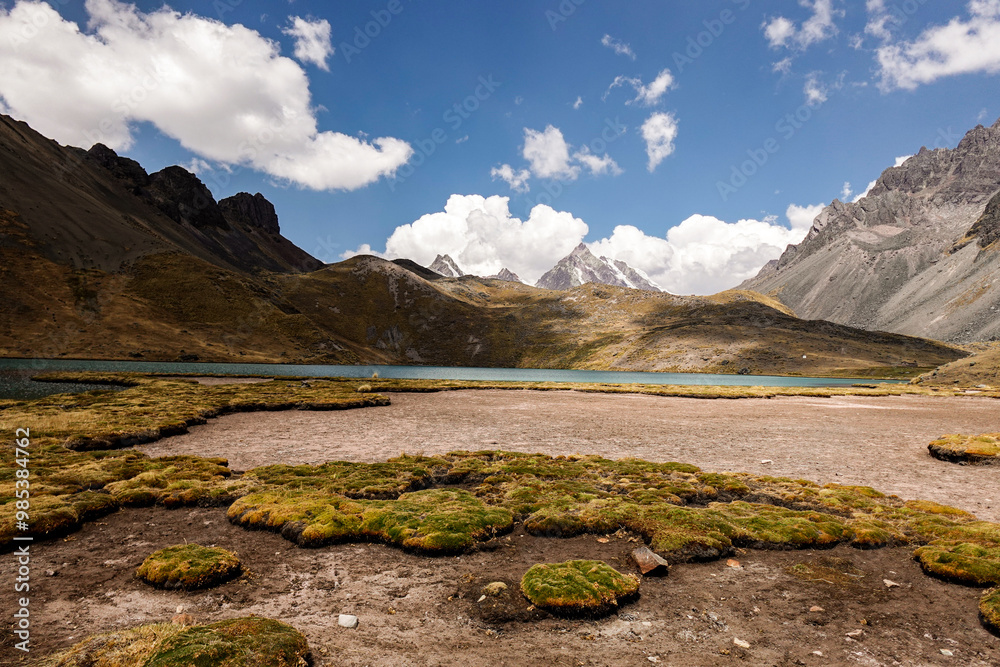 Laguna de color turquesa con playa rojiza cerca del nevado de Ausangate ...