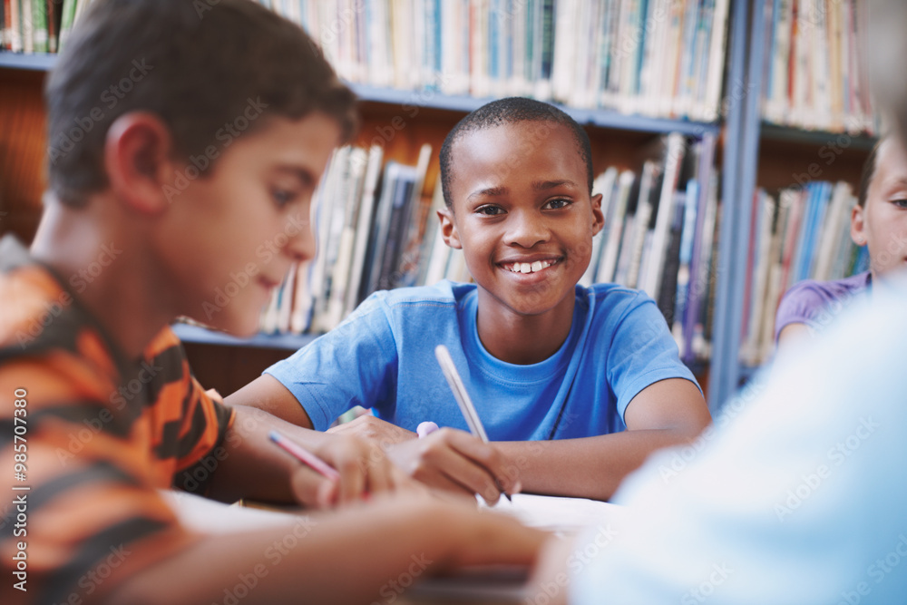 Black boy, writing and learning with books in library for assessment ...