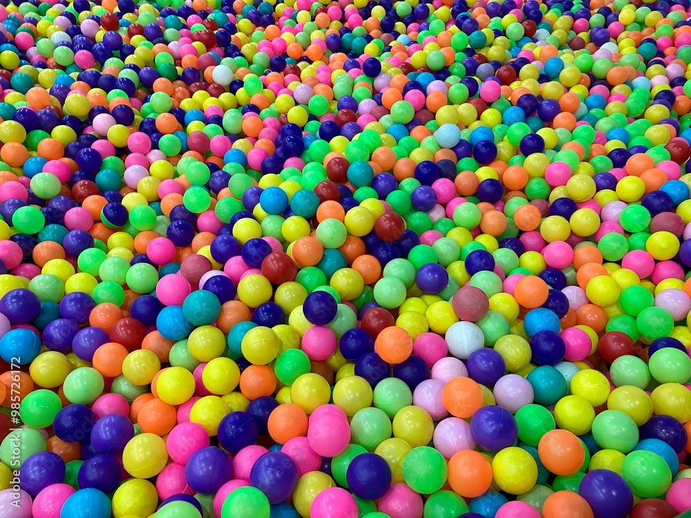 Thousands of colorful plastic balls in a pool known as a ball pool in ...