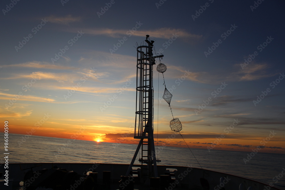 Front of fishing vessel sailing in the North Sea with a sunset in front ...