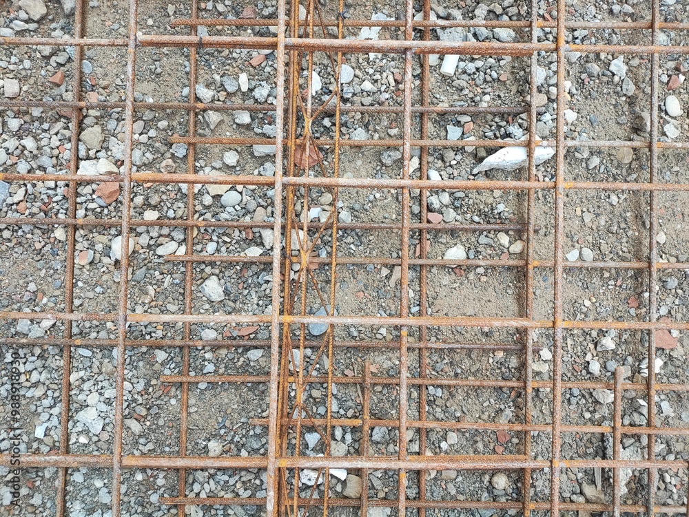 An overhead shot of rusty steel reinforcement bars arranged in a grid ...