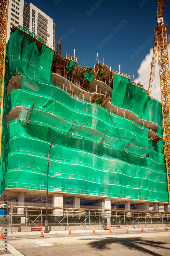 Building under construction covered with green safety debris tarp Stock ...