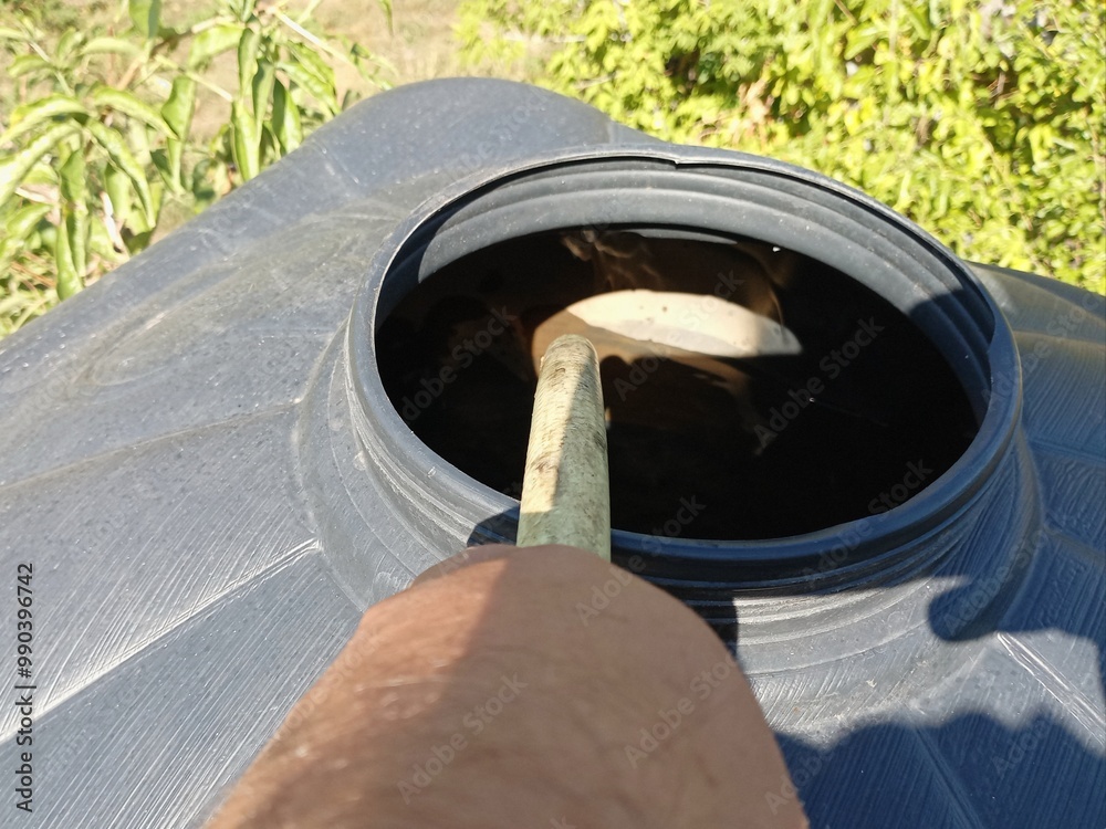 The process of collecting water in the black plastic tank of the summer ...