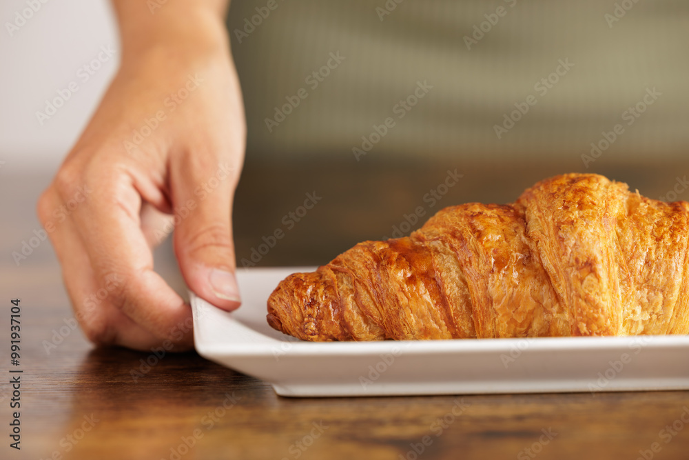 Person serving handmade croissant in bakery. Close-up portrait of ...