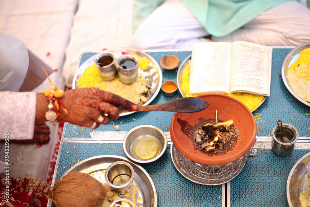 A Hindu ritual with offerings being made into a sacred fire, surrounded ...