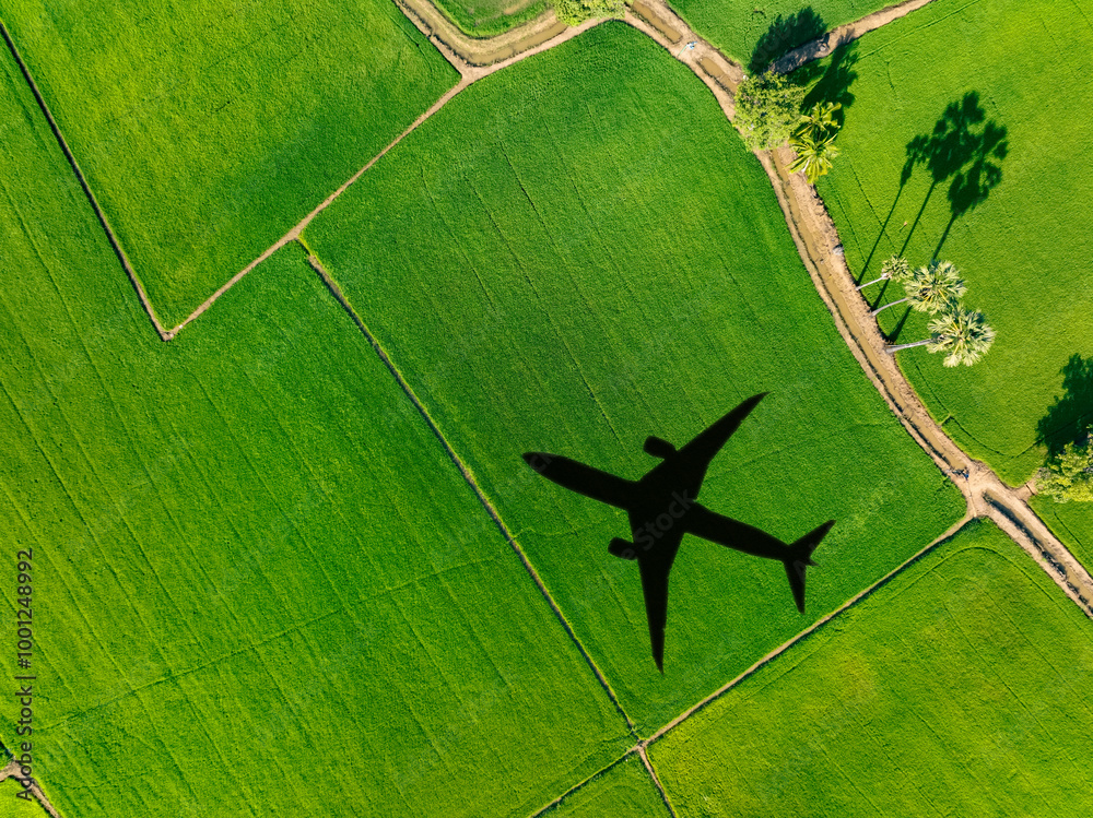 Shadow airplane flying above green field. Sustainable aviation fuel ...