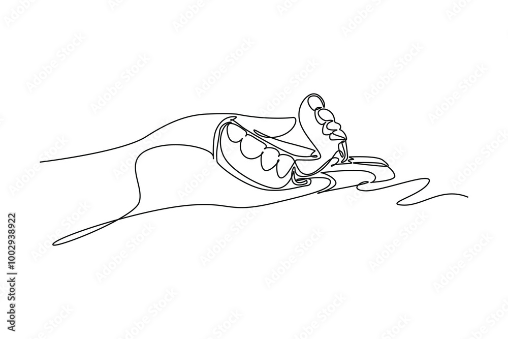 Continuous one line drawing dentist holds model of dental jaw in his ...