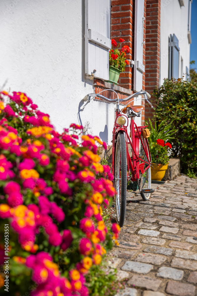 Vieux vélo rouge au pied d'une maison fleurie dans les rues d'un ...