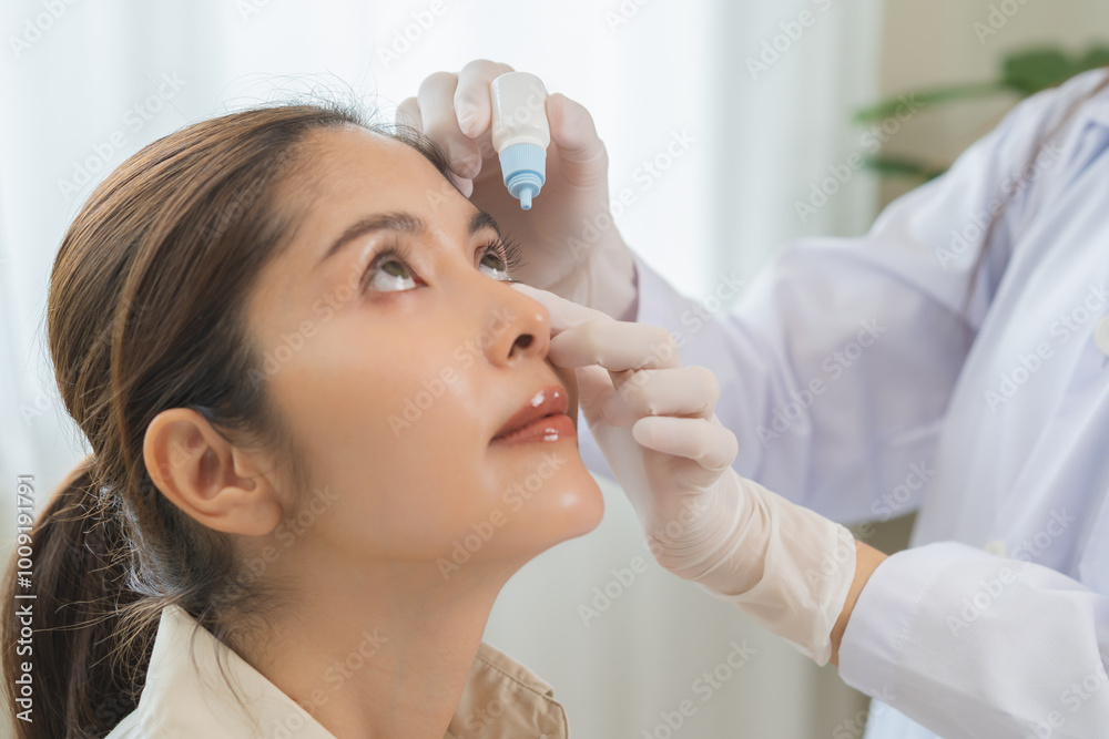 Health care concept, eye doctor eye drops to asian young woman patient ...