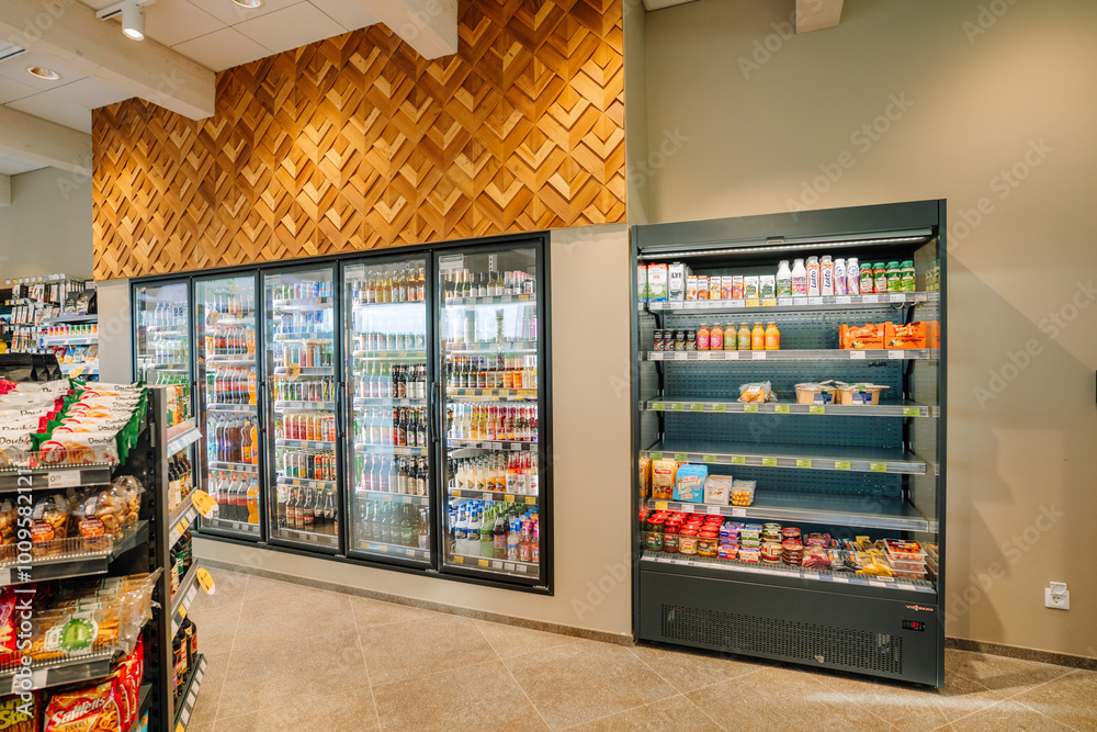 Convenience store shelves filled with refrigerated drinks, snacks, and ...