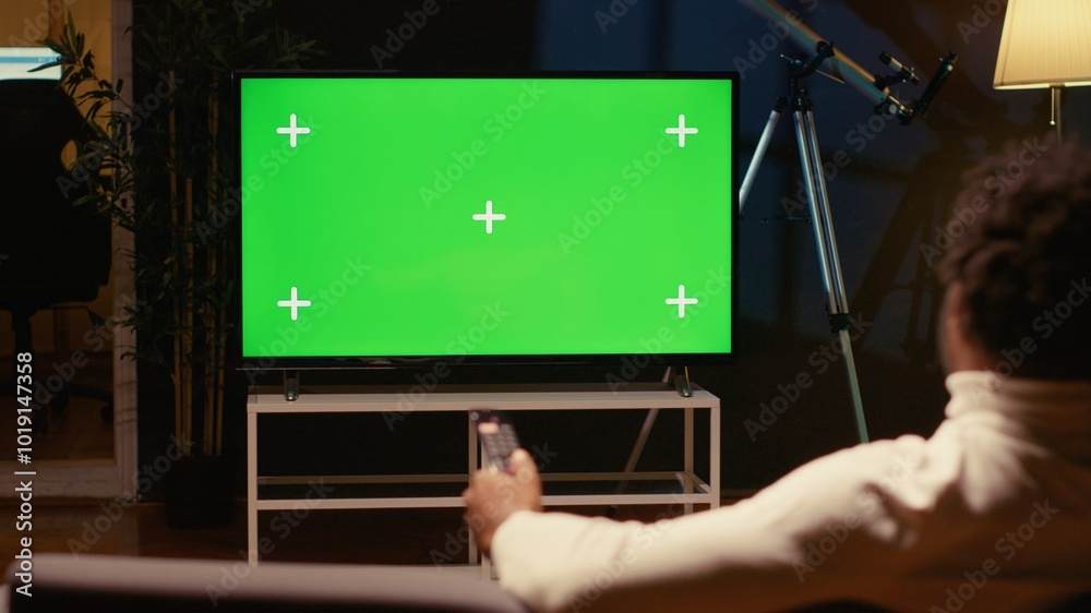 Man using remote to zap through films available on streaming services ...