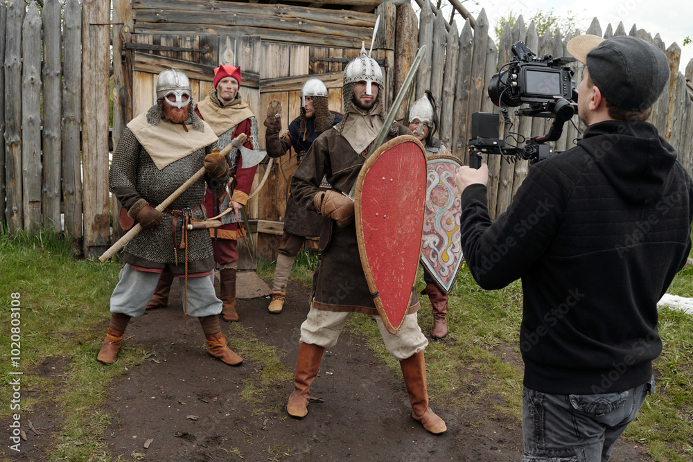 Medieval reenactors dressed in traditional armor and carrying shields ...